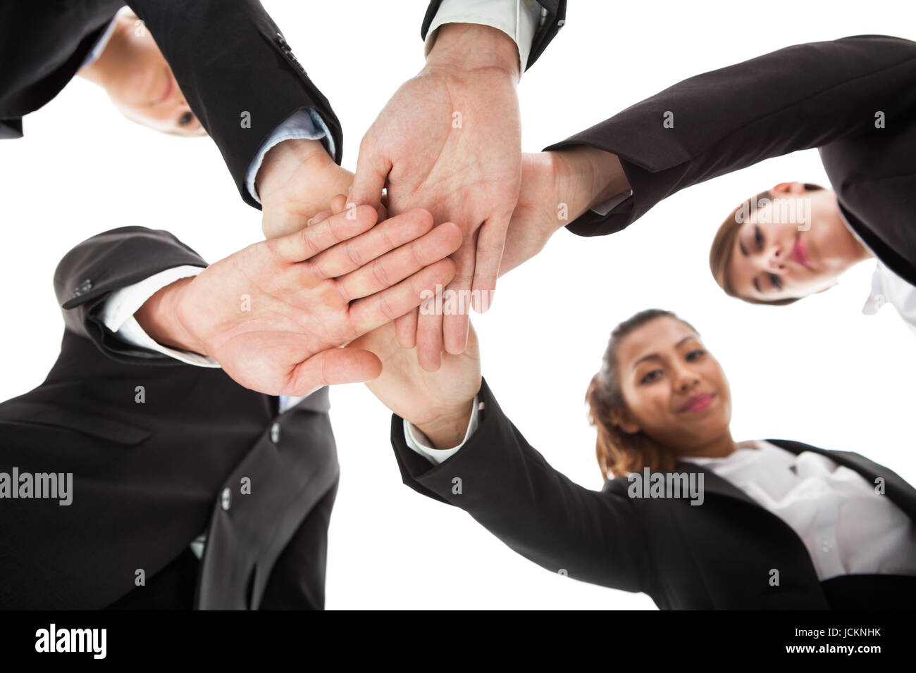Low angle view of businesspeople stacking hands against white ...