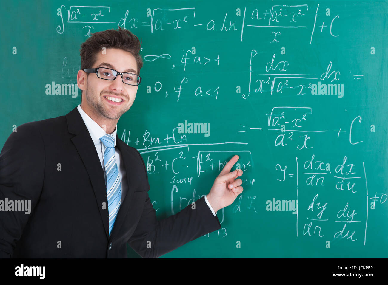 Portrait of confident young male professor standing against blackboard ... Portrait of confident young male professor standing against blackboard ...
