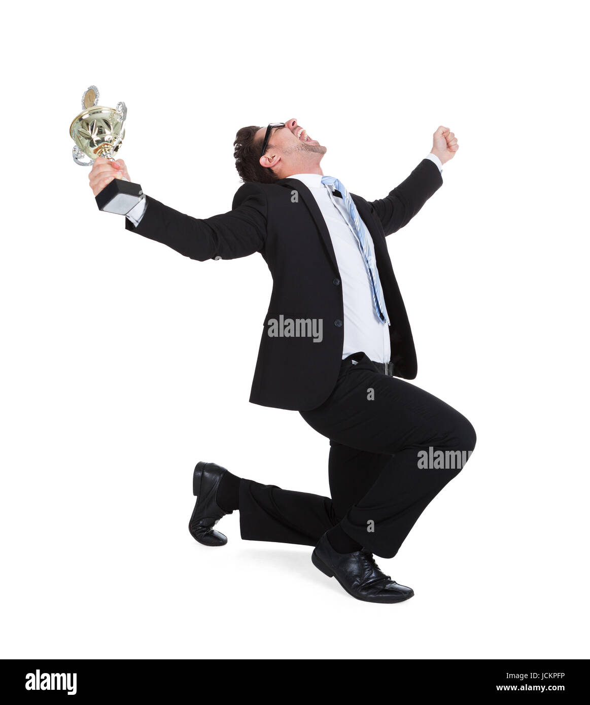 Full length of successful young businessman with trophy screaming over ...