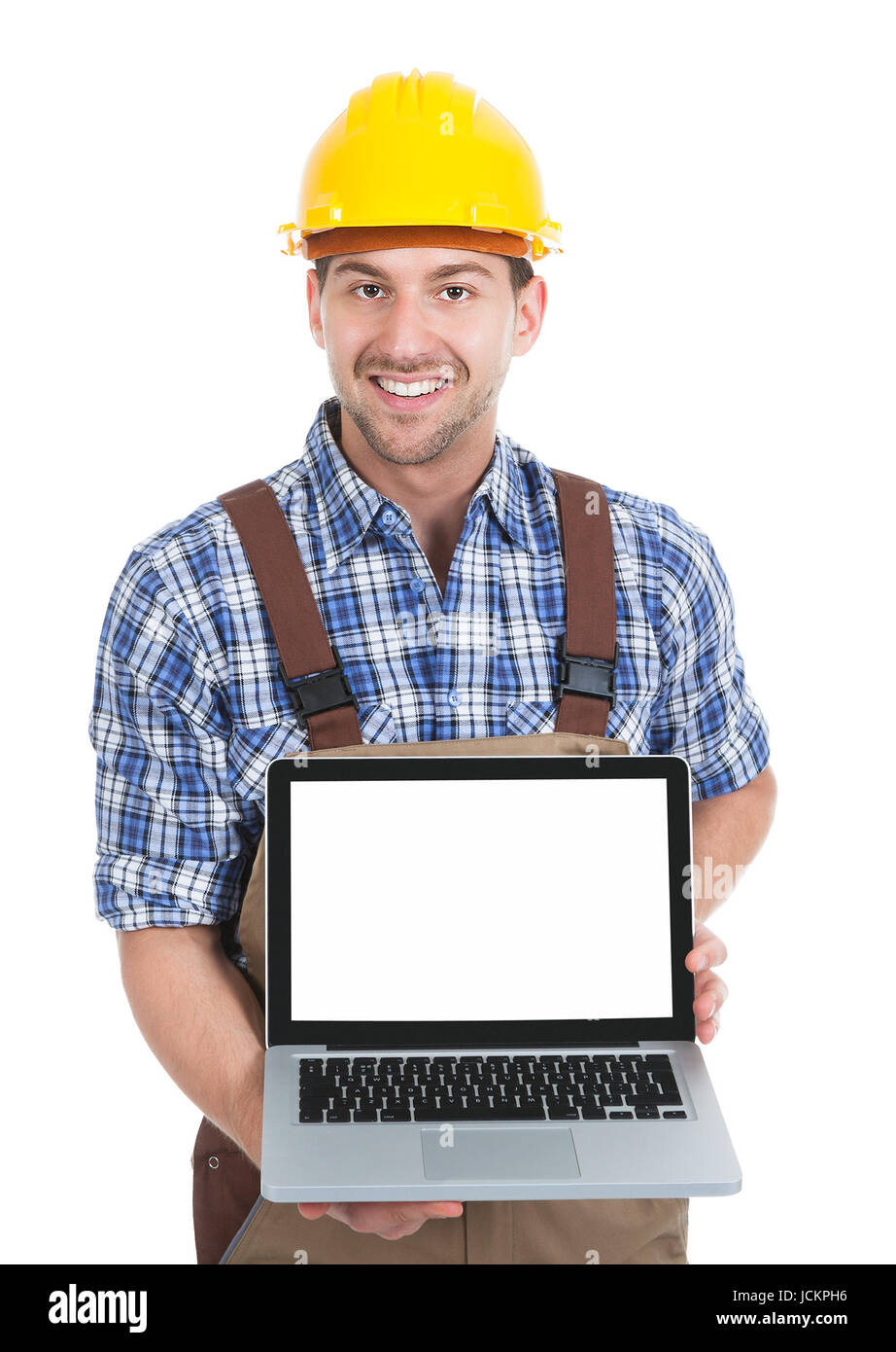 Portrait of young manual worker displaying laptop over white background ...