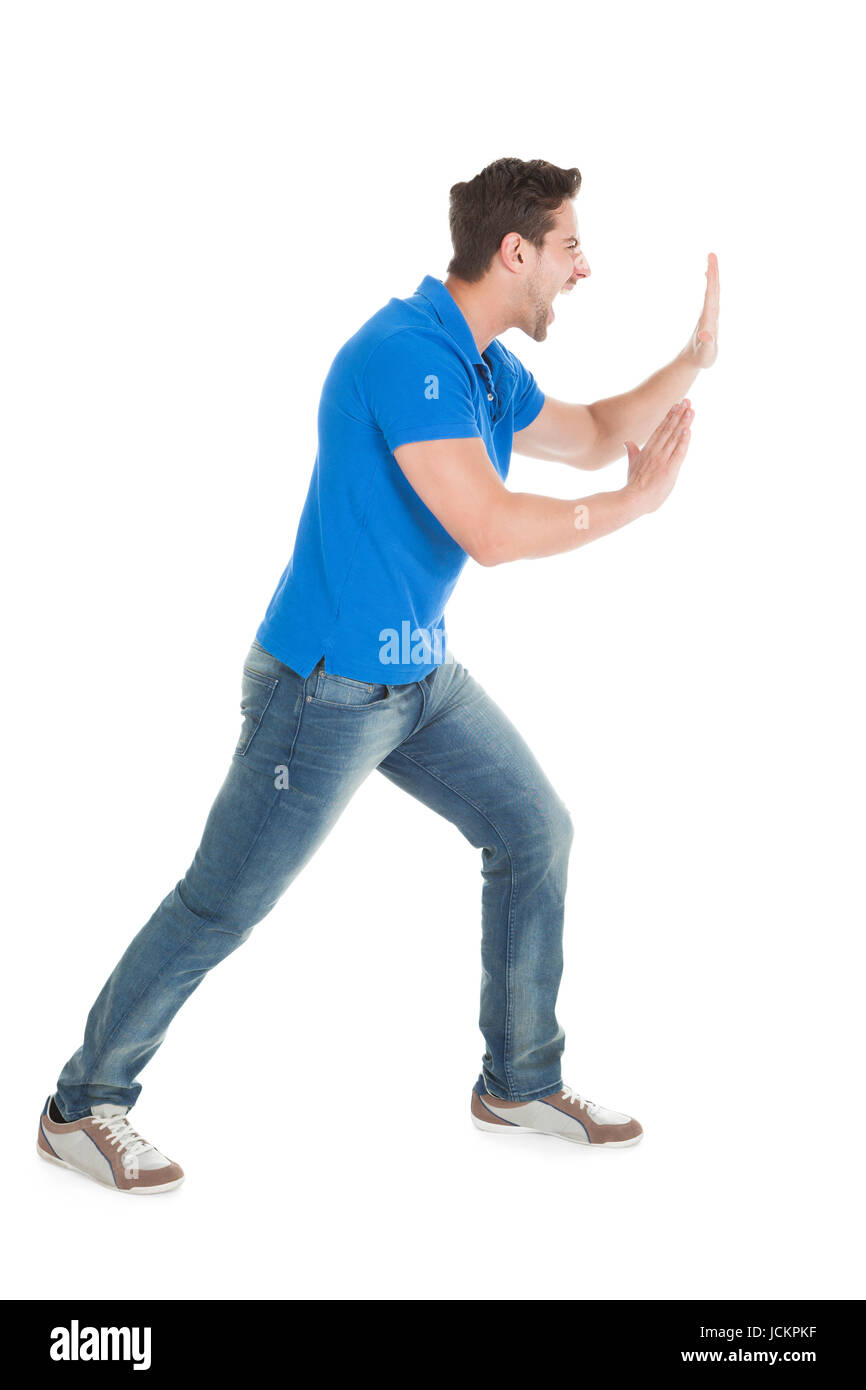 Full length portrait of confident man pushing billboard over white ...