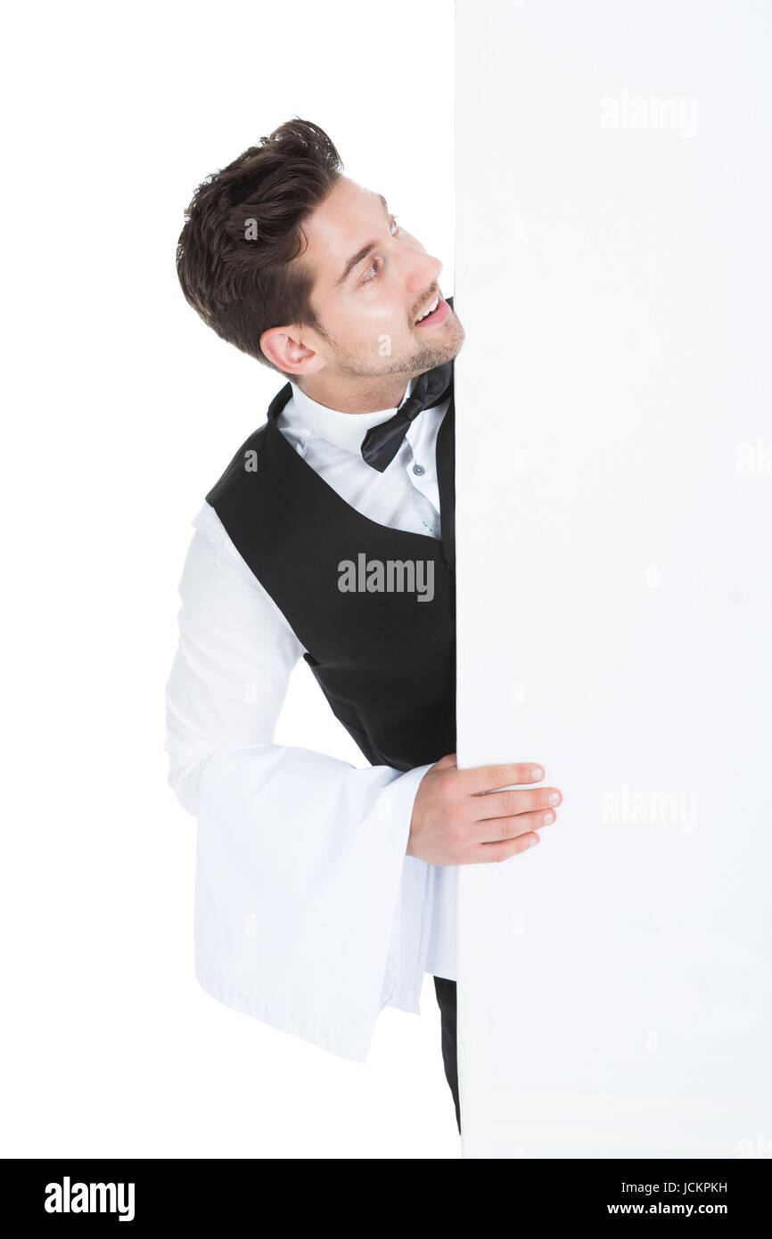 Young butler looking at blank billboard isolated over white background ...