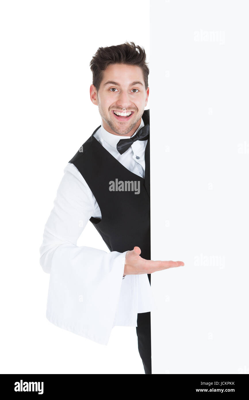 Young butler looking at blank billboard isolated over white background ...
