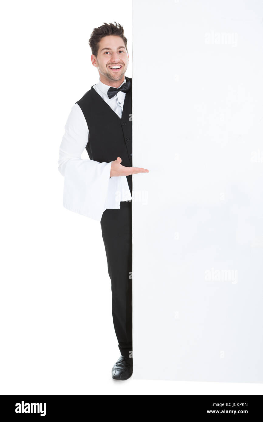 Young butler looking at blank billboard isolated over white background ...
