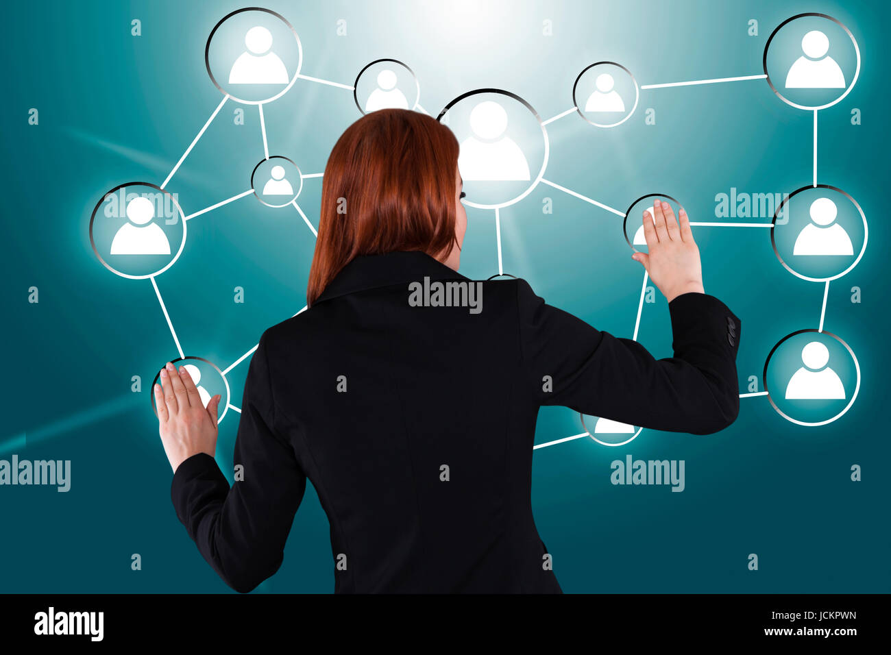 Rear view of businesswoman touching connected human icons over green ...
