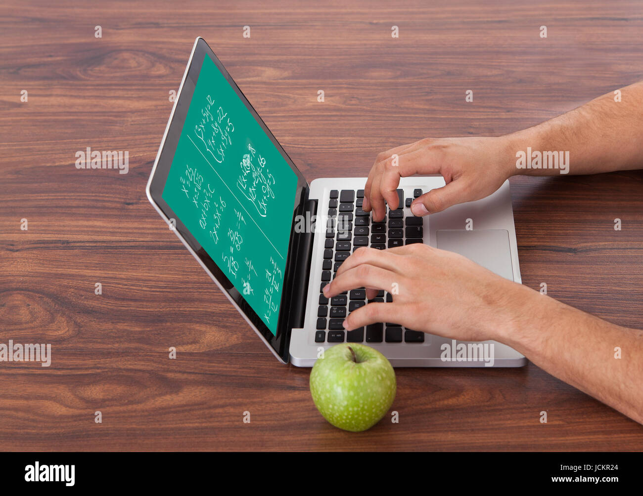 Cropped image of young male student solving math's problem on laptop by ...