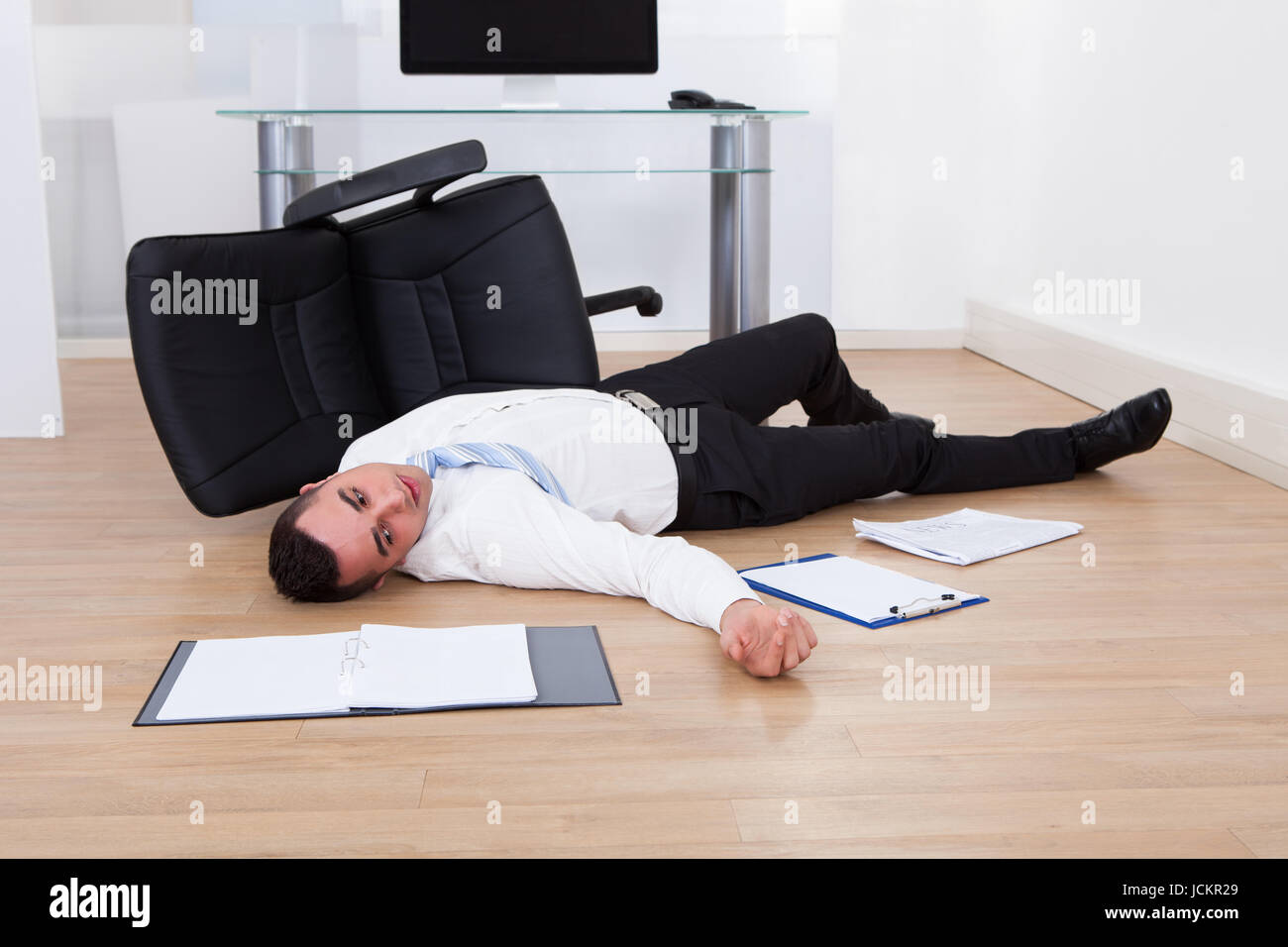 Full length of young businessman fallen from office chair Stock Photo ...
