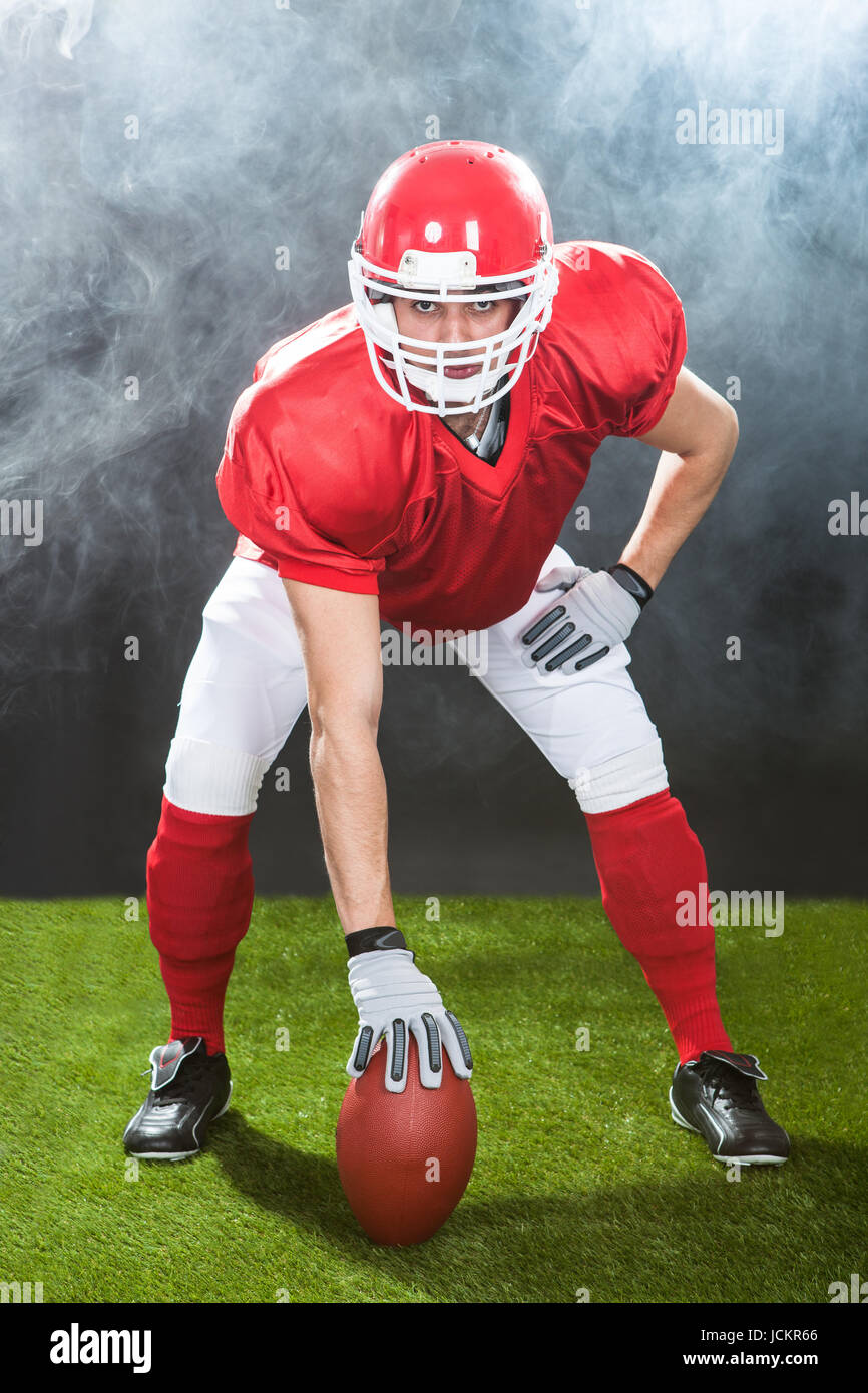 Full length portrait of confident American football snapper on field at ...