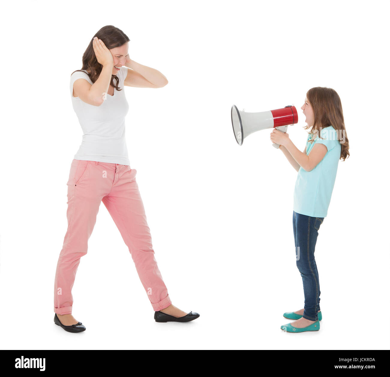 Full length of angry daughter shouting through megaphone at mother ...