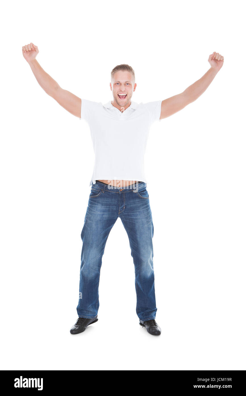 Handsome man cheering in exultation punching the air with his fists as ...