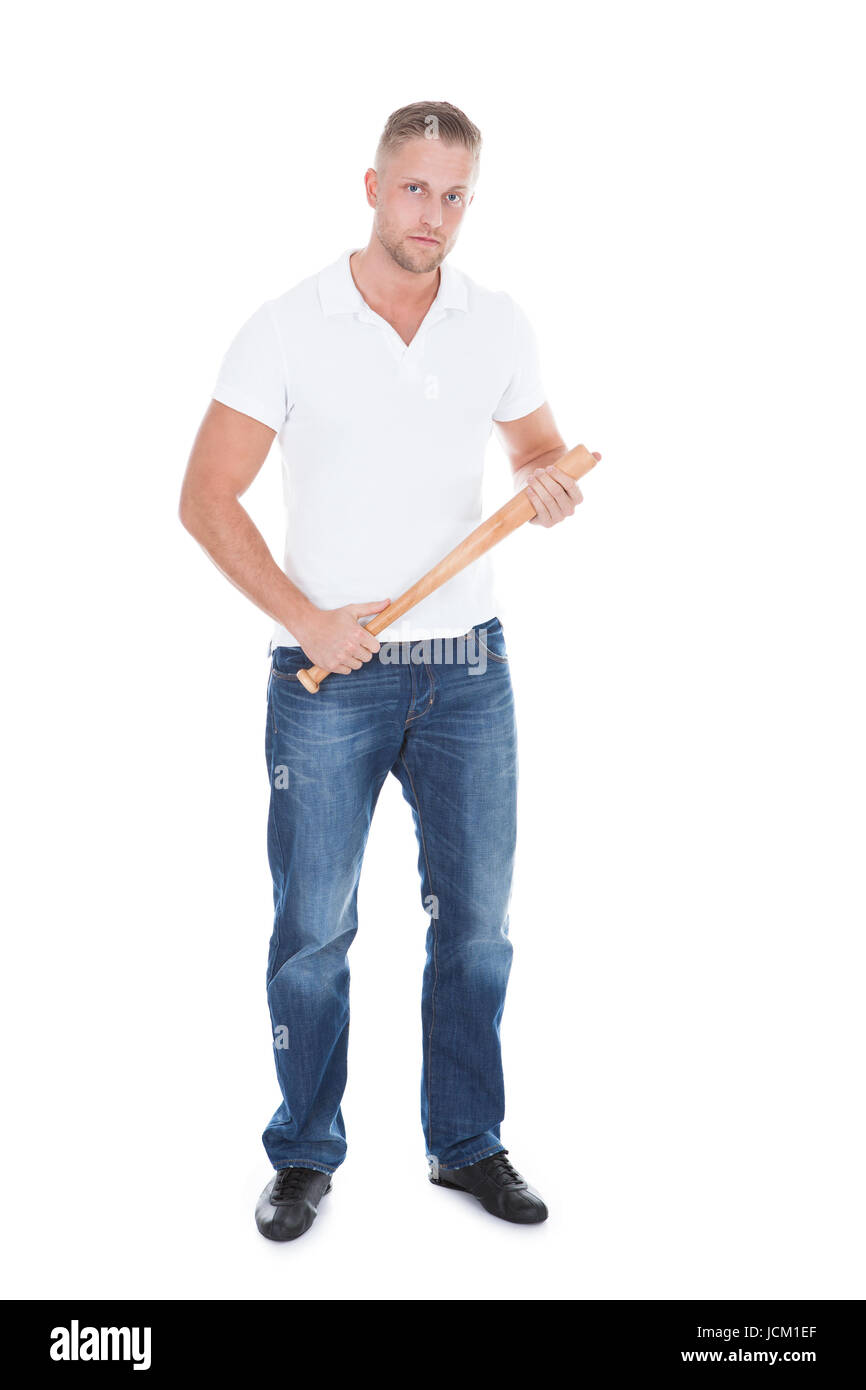 Bully or thug standing holding a baseball bat in his hands and looking ...