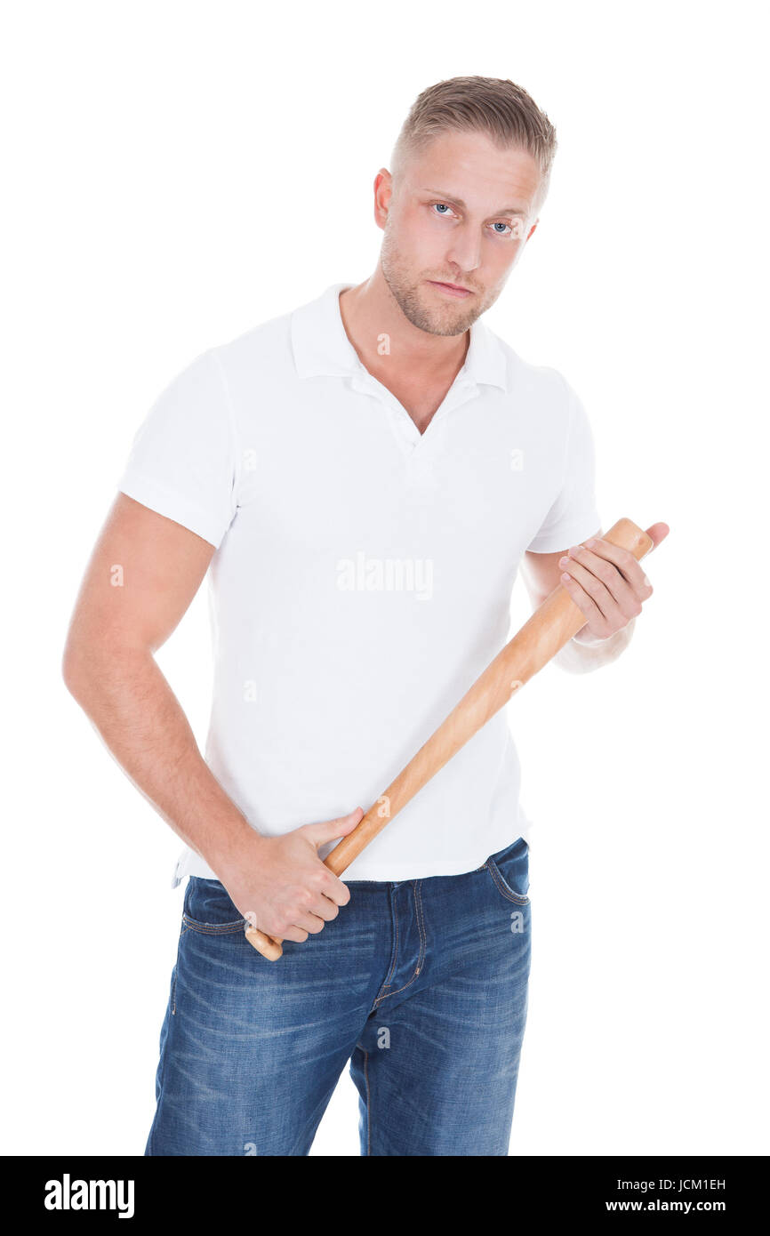 Bully or thug standing holding a baseball bat in his hands and looking ...