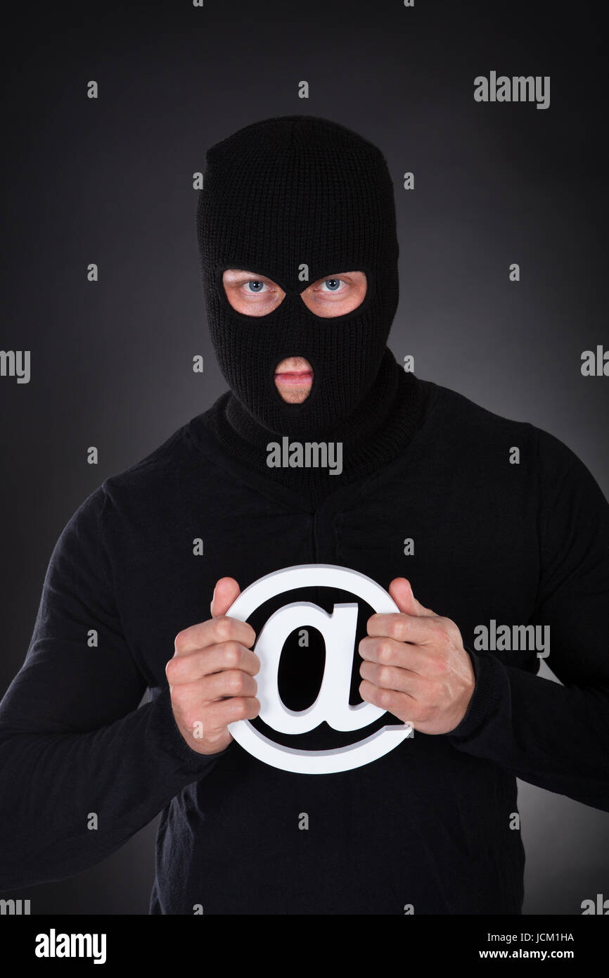 Hacker dressed in black wearing a balaclava with a white internet ...