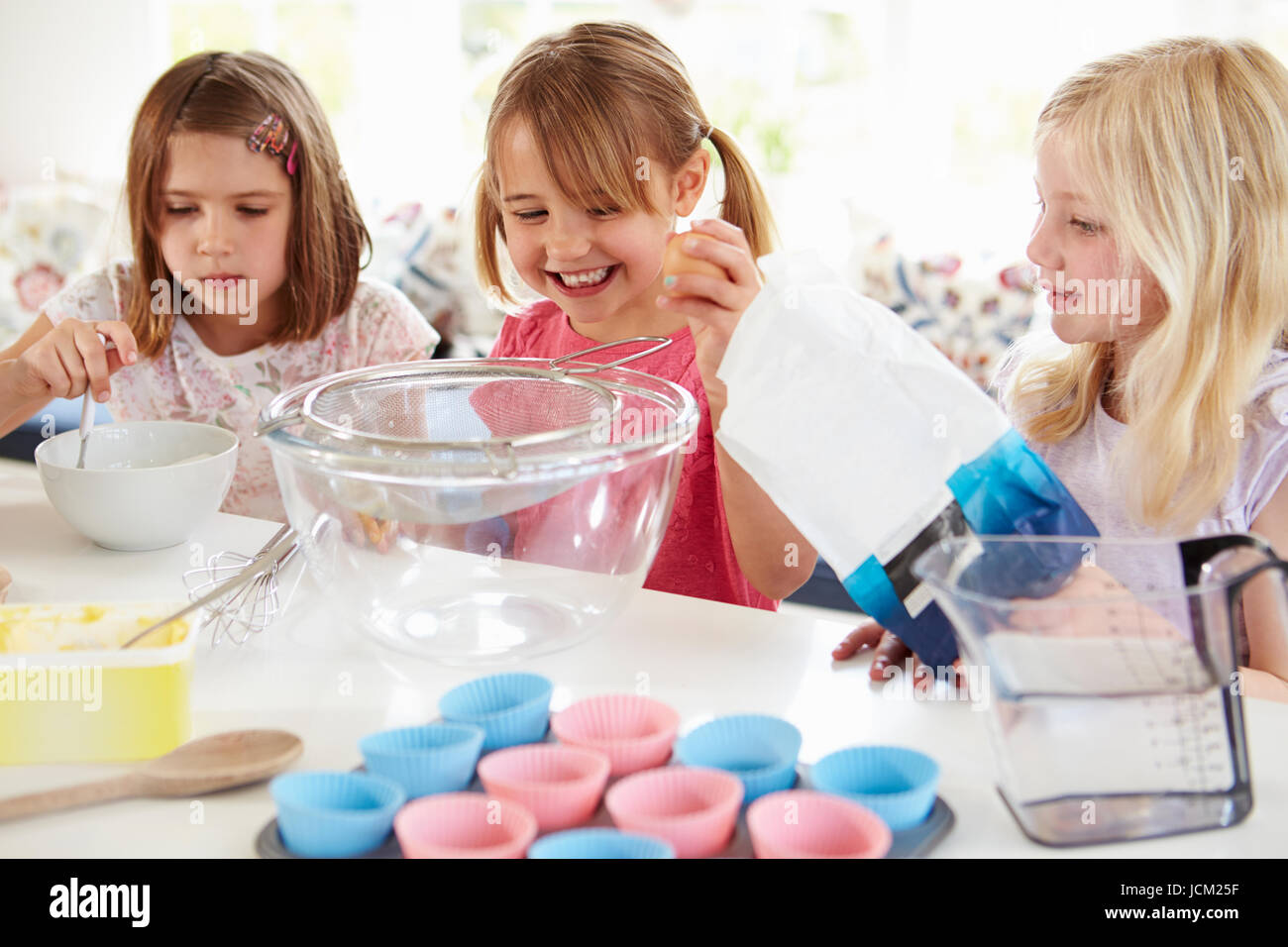 Three Girls Making Cupcakes In Kitchen Stock Photo - Alamy