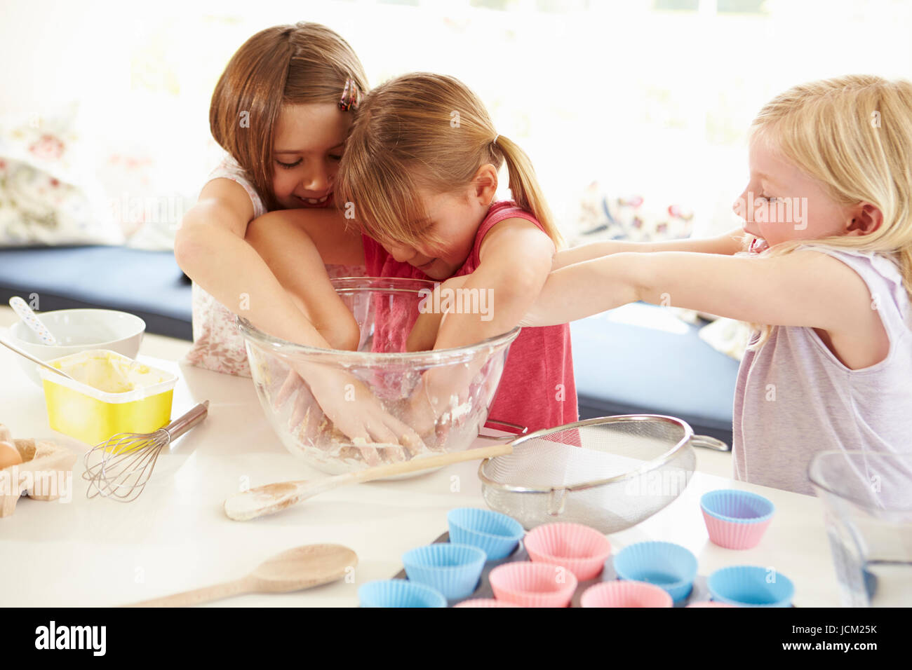 Three Girls Making Cupcakes In Kitchen Stock Photo - Alamy