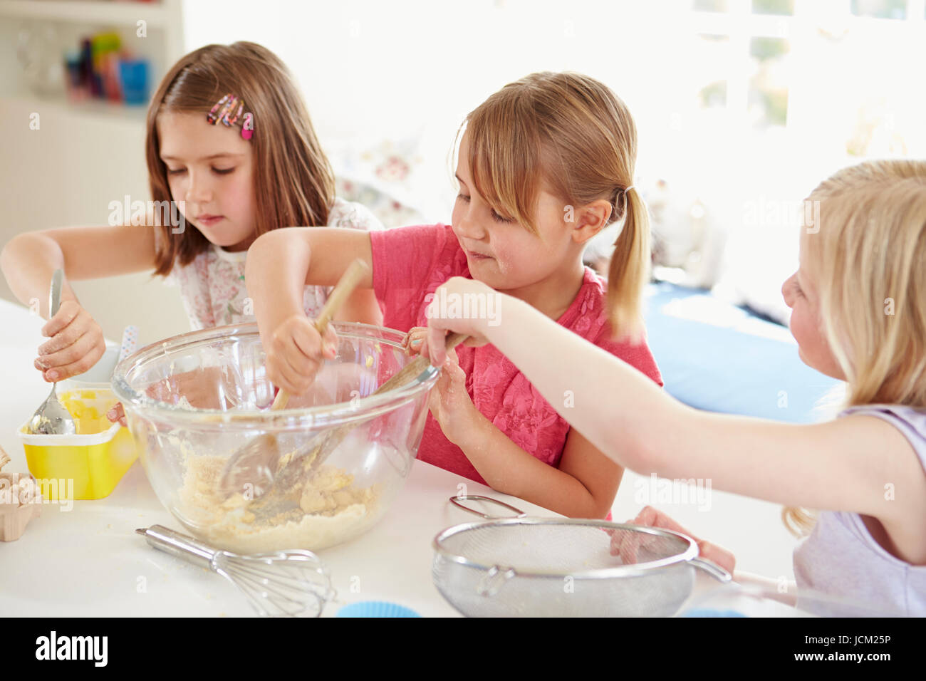 Three Girls Making Cupcakes In Kitchen Stock Photo - Alamy