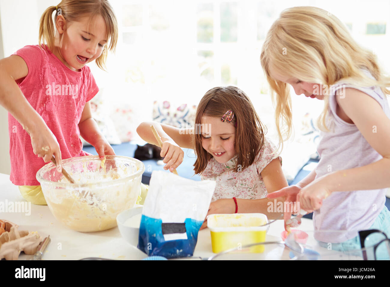 Three Girls Making Cupcakes In Kitchen Stock Photo - Alamy