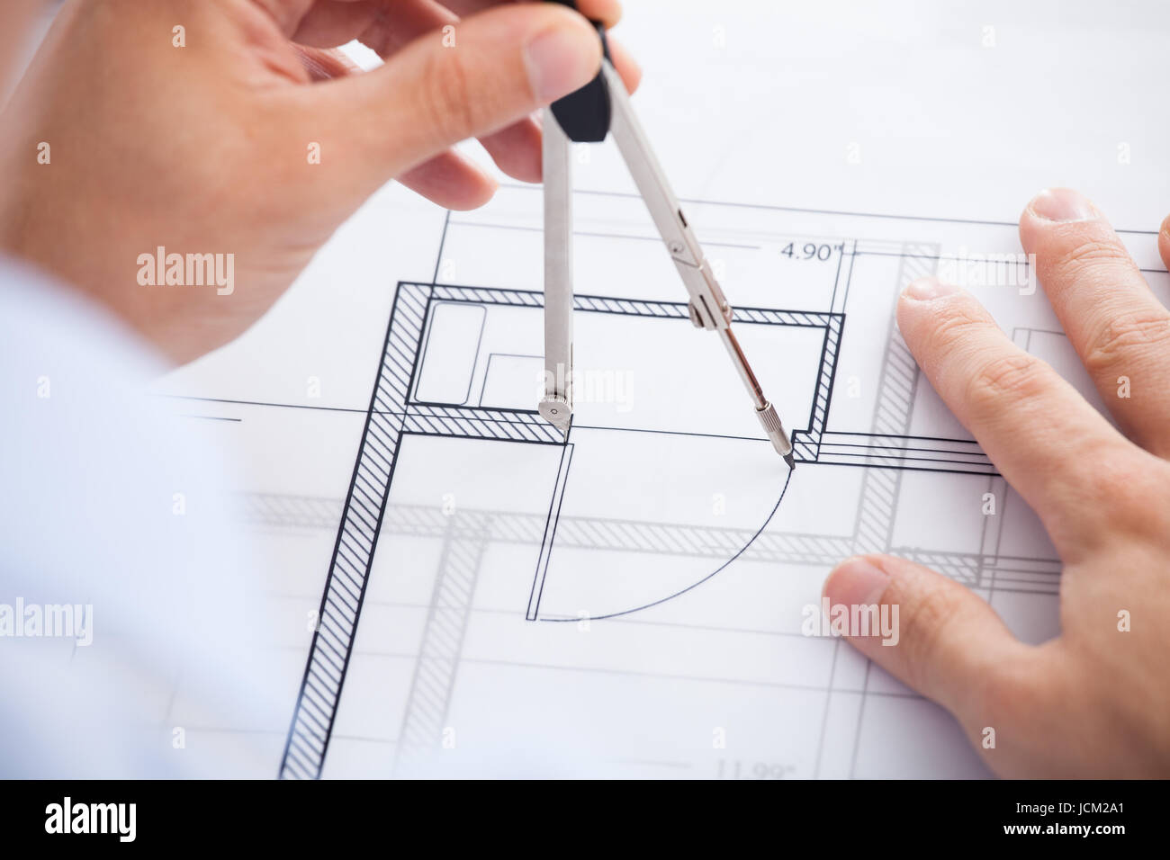 Cropped image of male architect using divider on blueprint in office ...