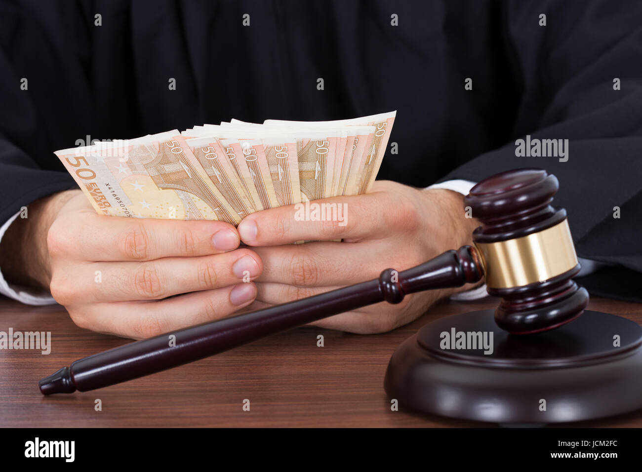 Midsection of male judge counting money at desk in courtroom Stock ...
