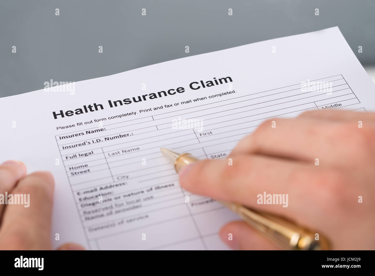 Hand filling health insurance claim form. Closeup shot Stock Photo - Alamy