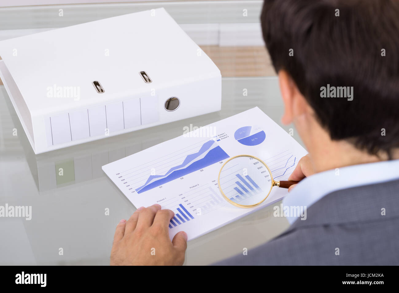 Magnifying glass over financial graph hi-res stock photography and ...