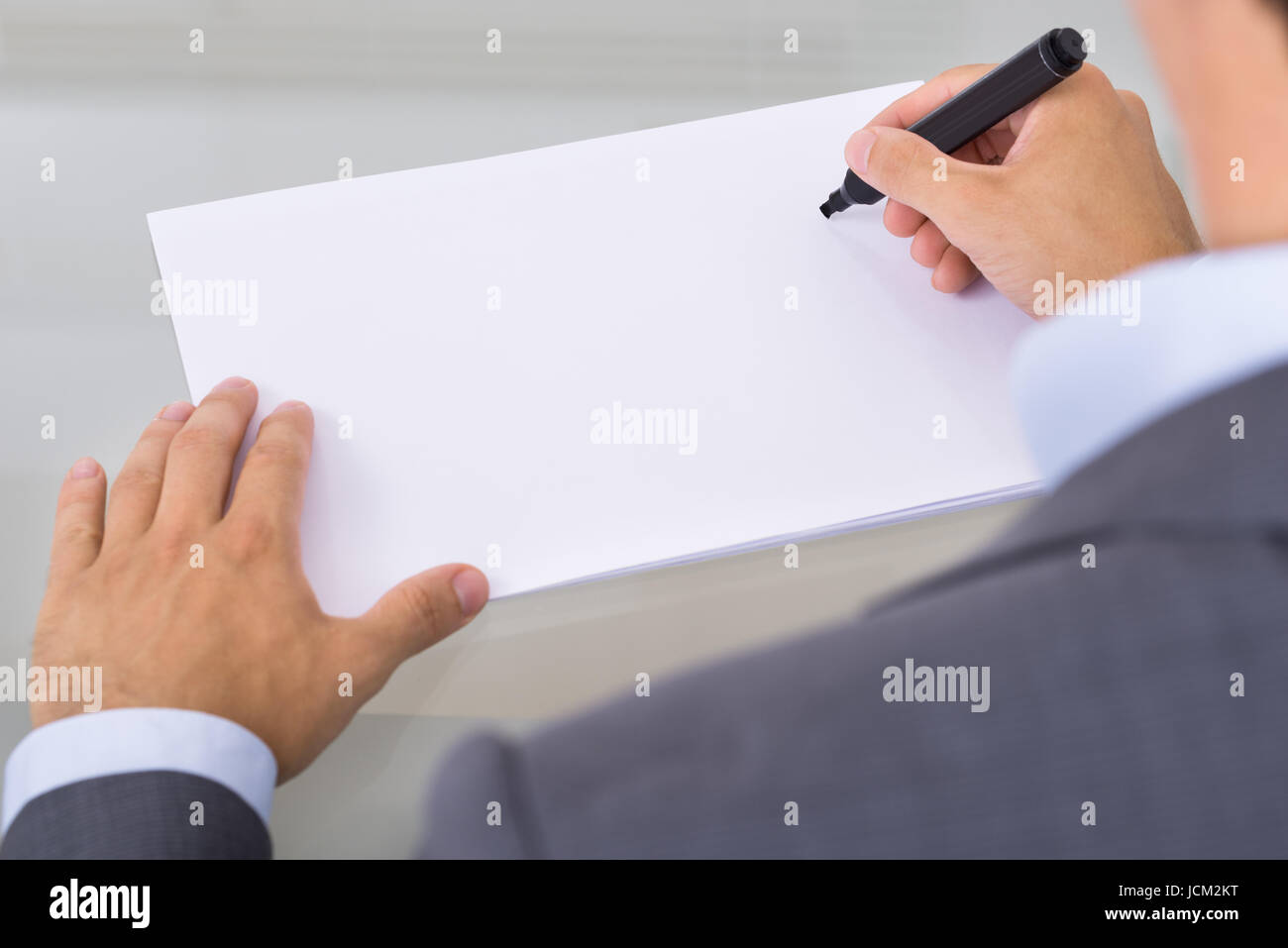 Businessman writing on empty paper sheet. Over the shoulder view Stock ...
