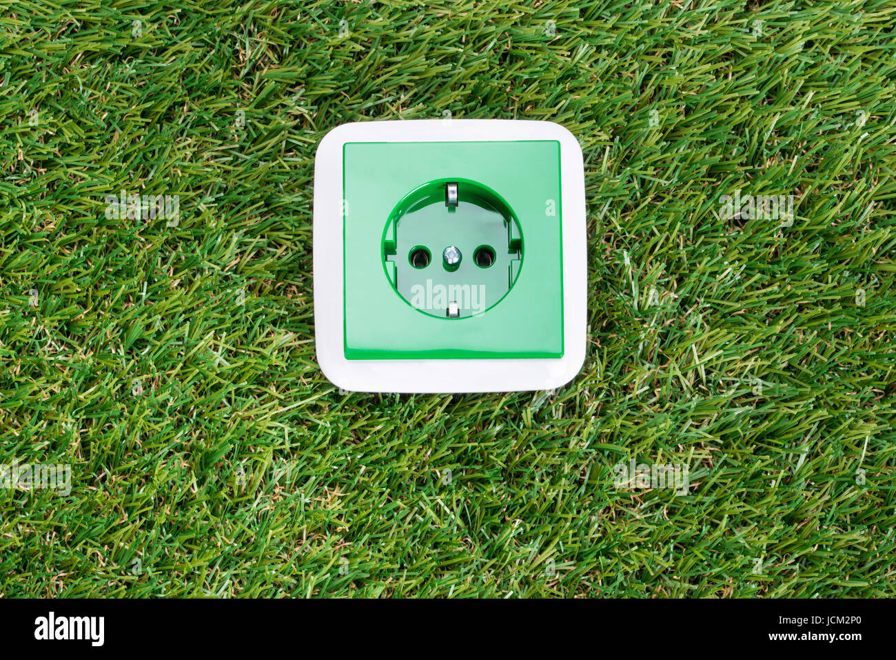 Wall socket on grass. Green energy concept Stock Photo - Alamy