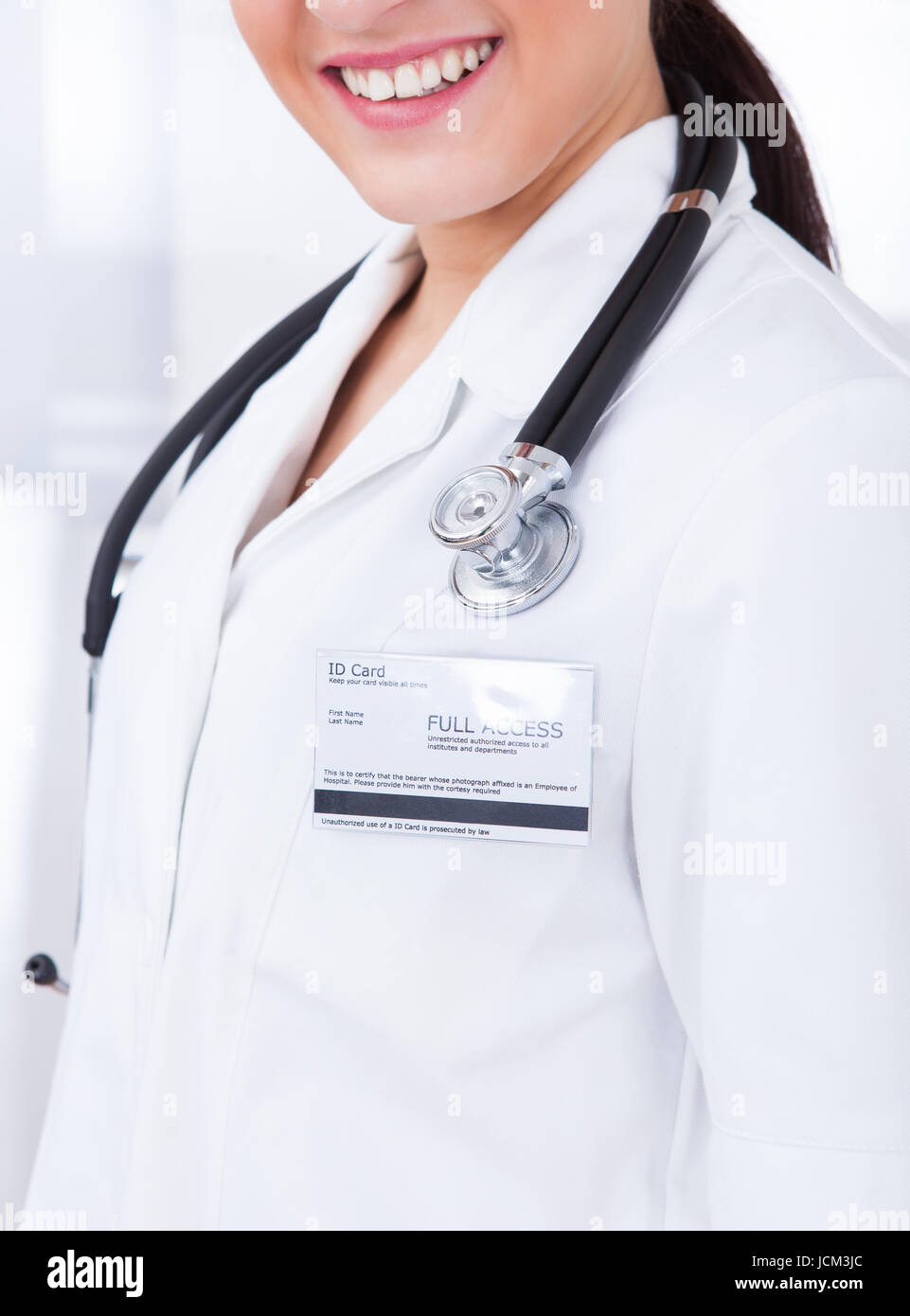 Midsection of female doctor with ID card and stethoscope Stock Photo ...