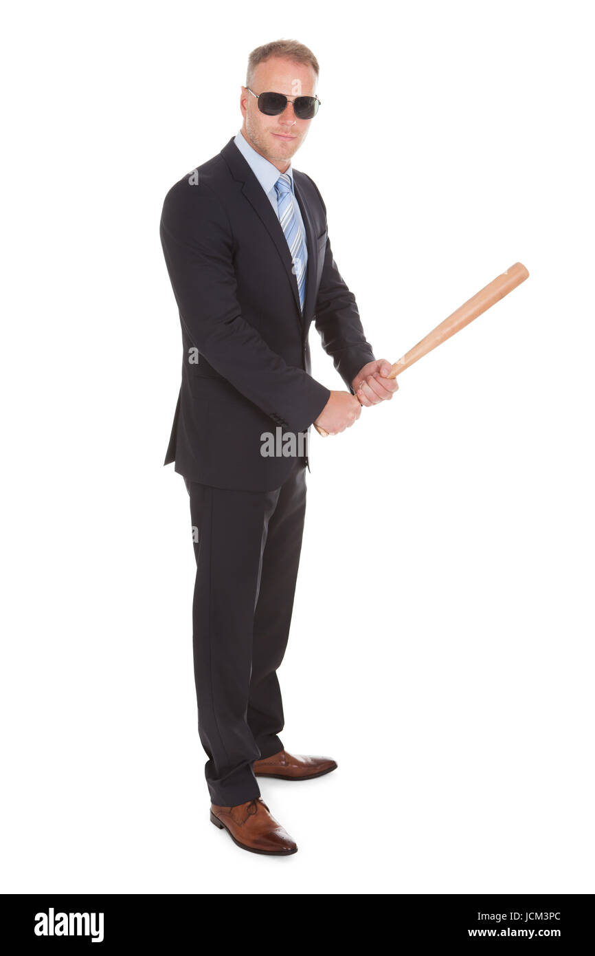 Full length portrait of mid adult businessman holding baseball bat over ...