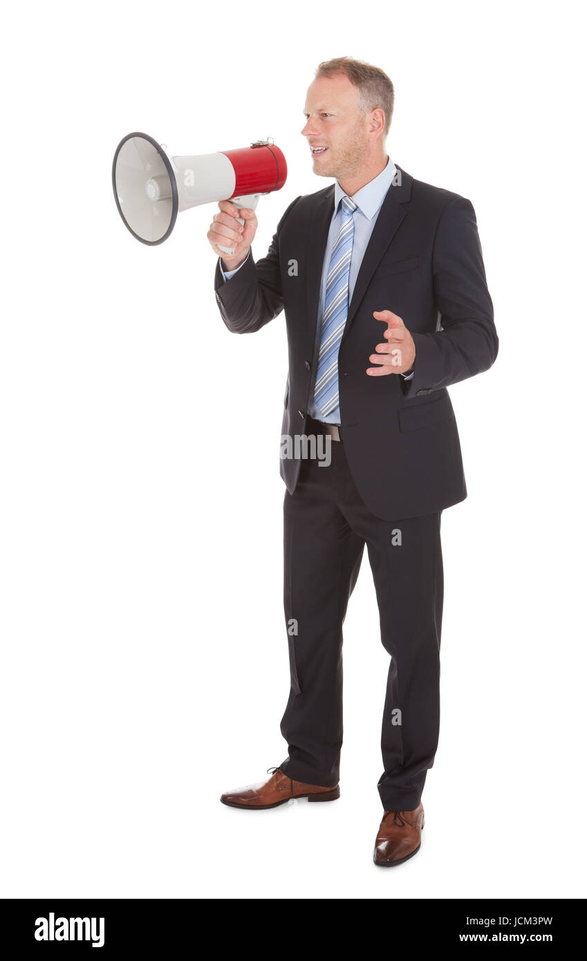 Full length of mid adult businessman using bullhorn over white ...