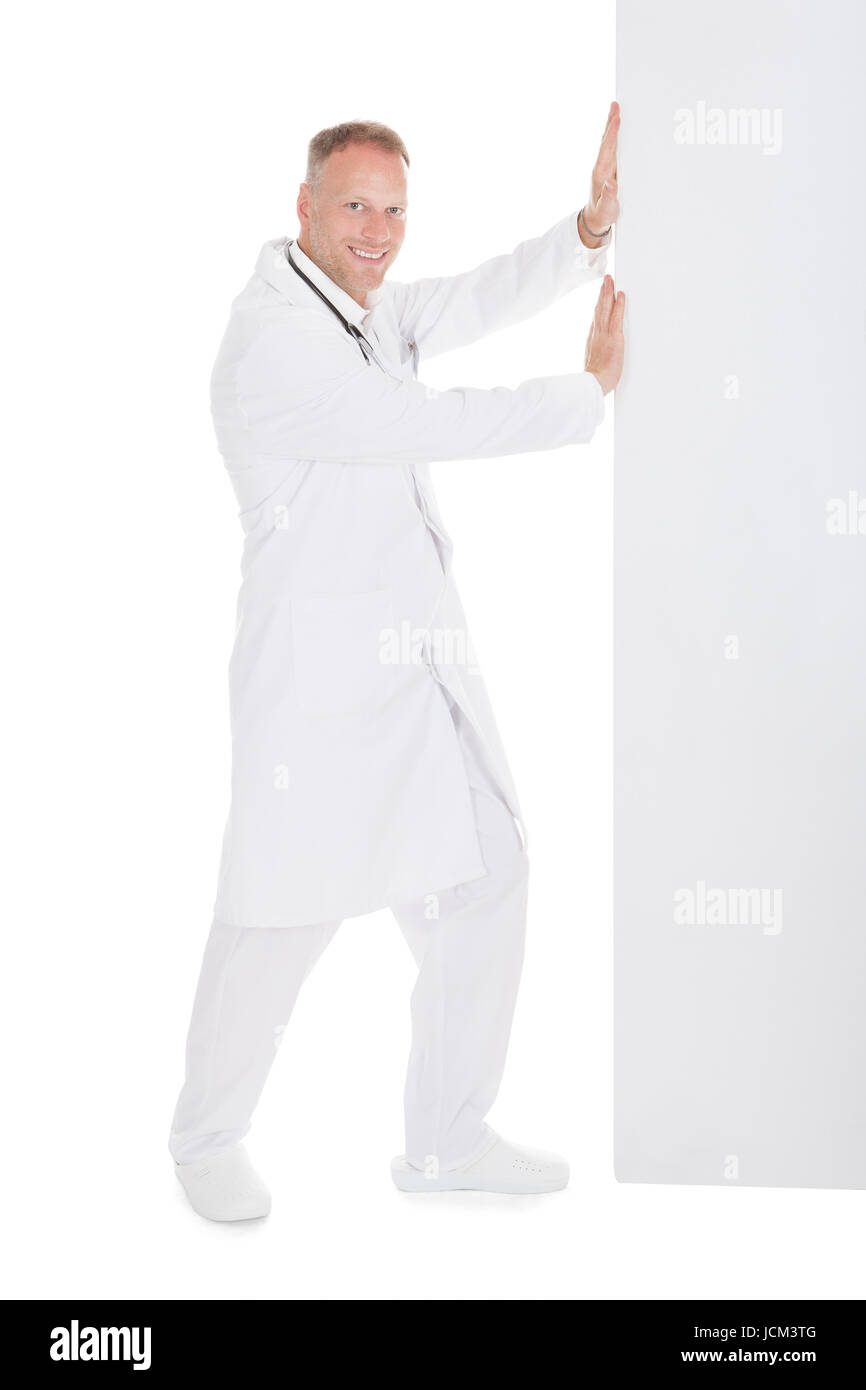 Full length side view of young male doctor pushing something over white ...