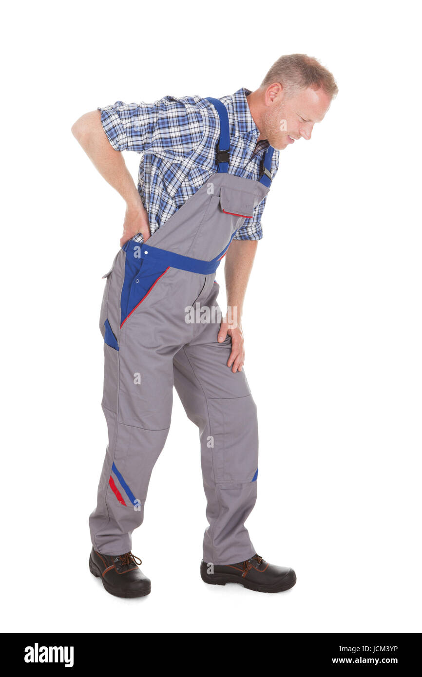 Full length of male worker suffering from back pain over white ...