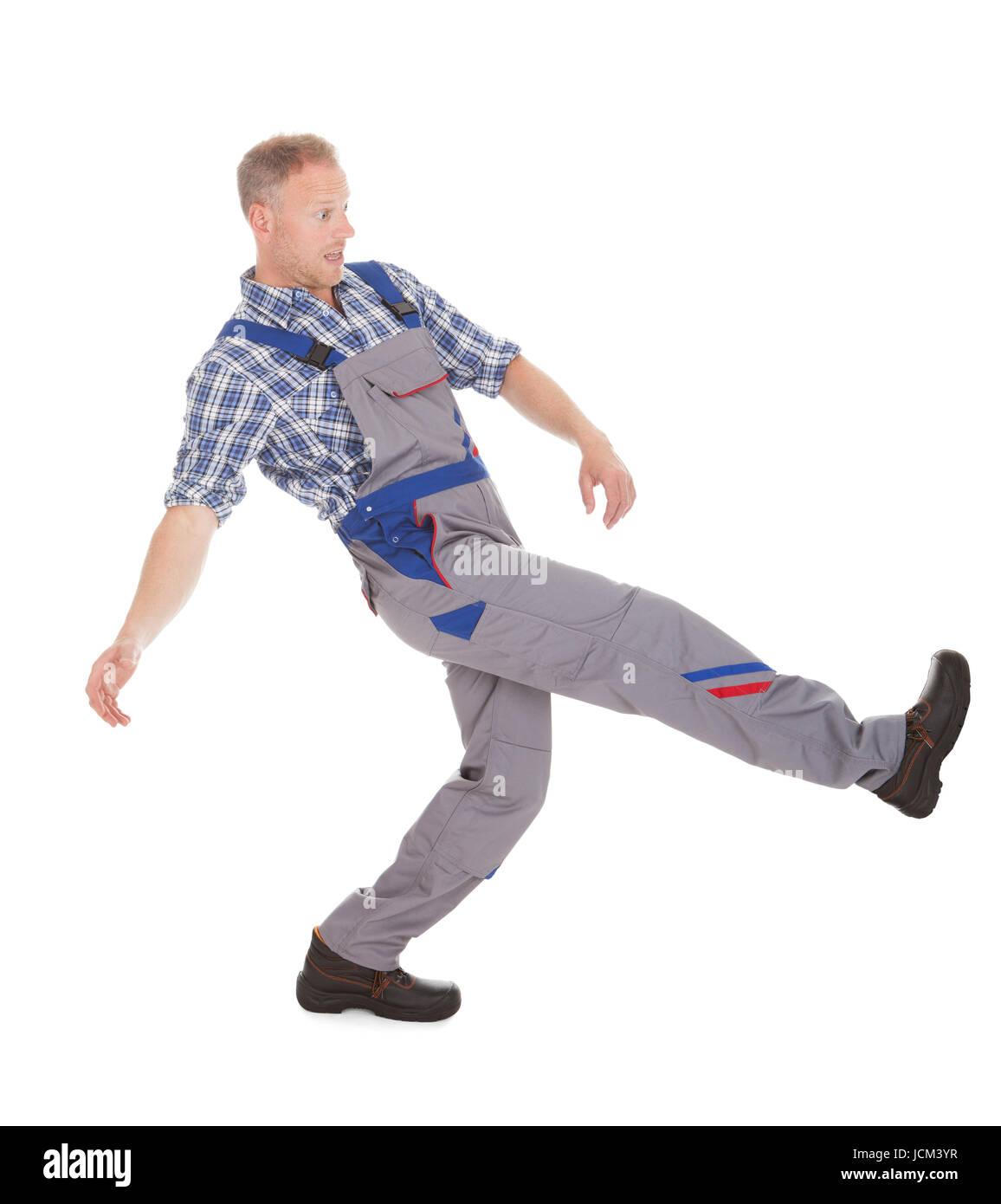 Full length of scared male worker slipping over white background Stock ...
