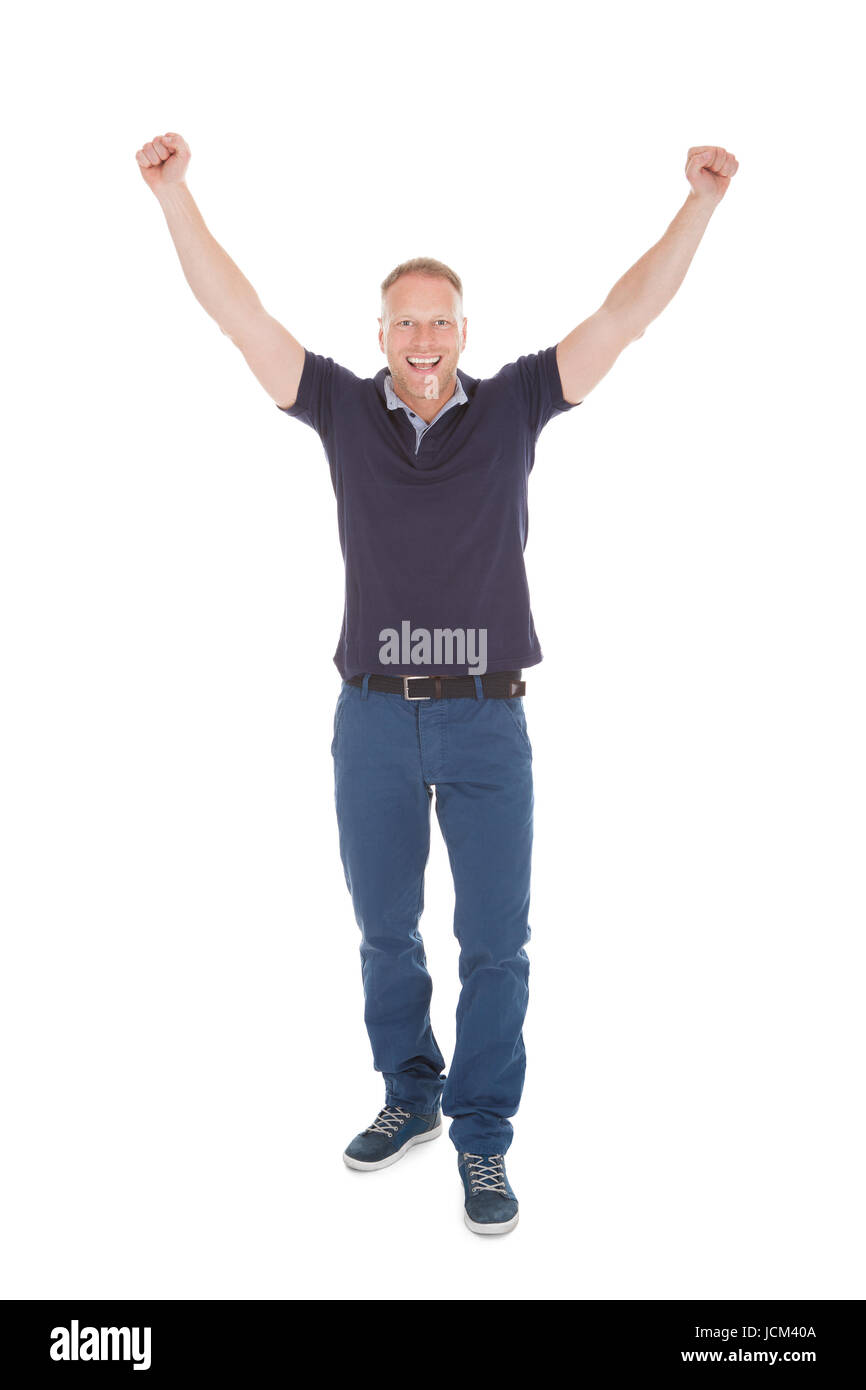 Portrait of cheerful young man with hands raised standing isolated on ...