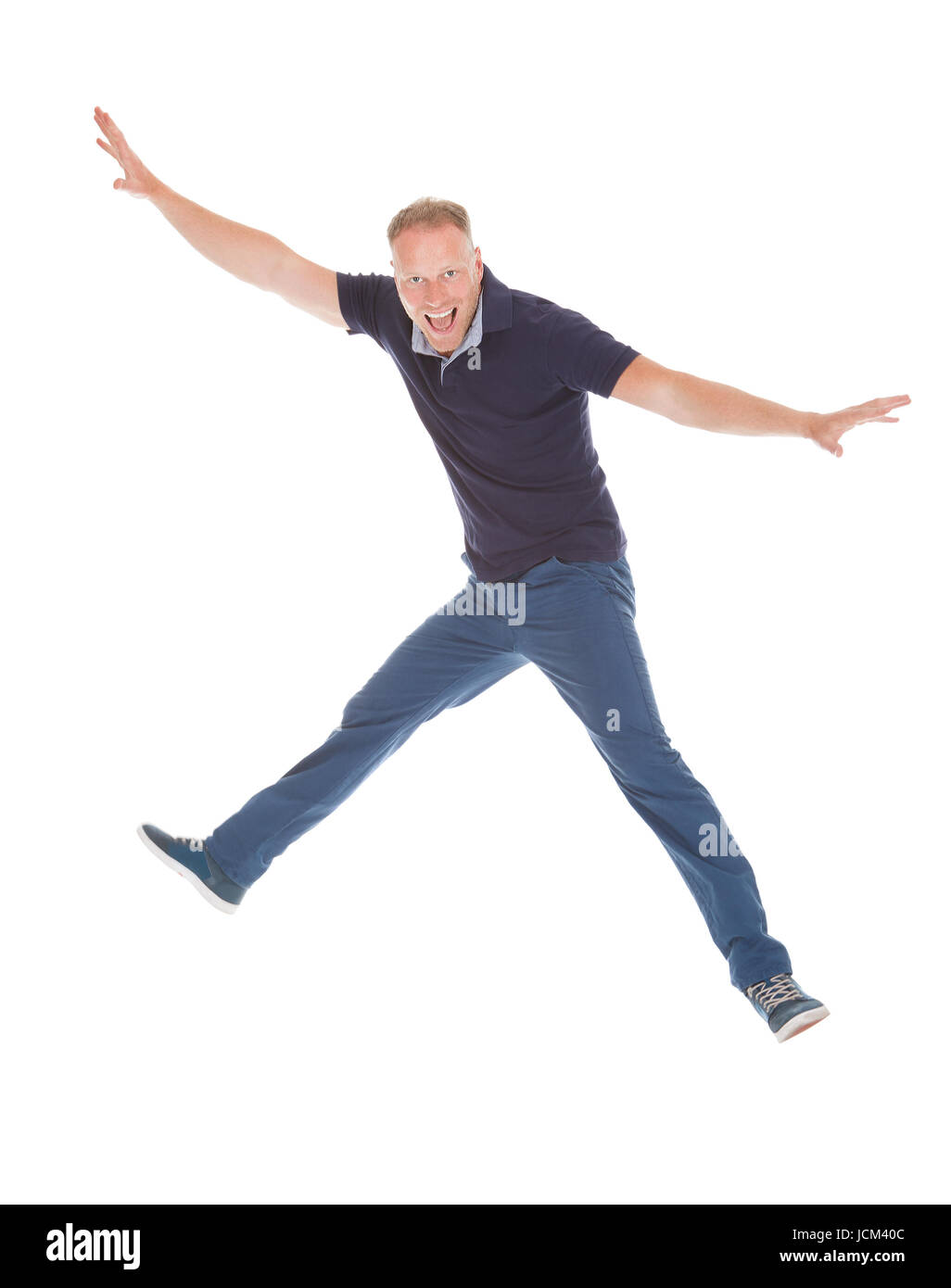 Portrait of cheerful young man with hands raised standing isolated on ...