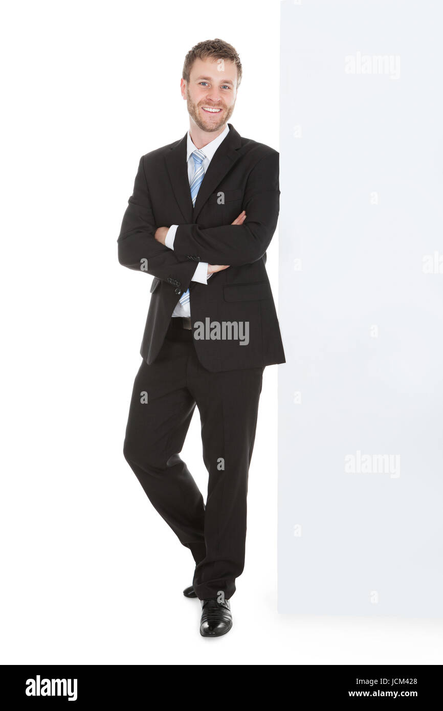 Full length portrait of mid adult businessman leaning over white ...