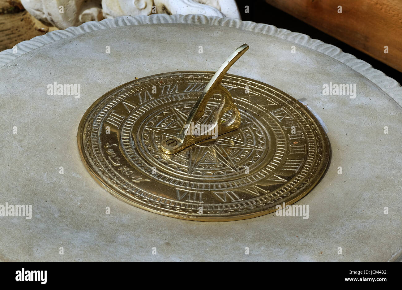 Brass decorative sundial on concrete base for use as a garden ornament ...