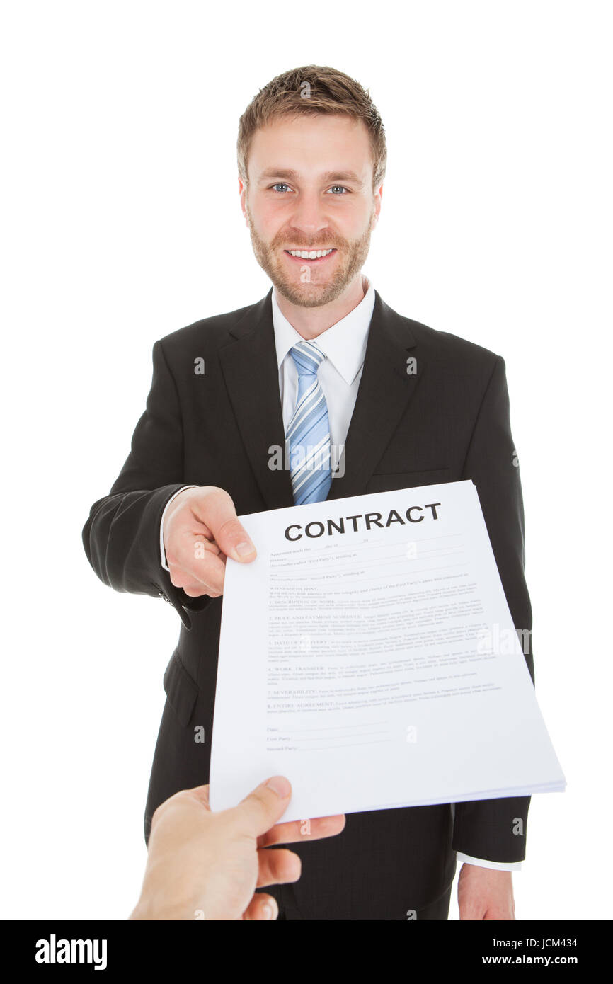 Portrait of happy businessman giving contract paper over white ...