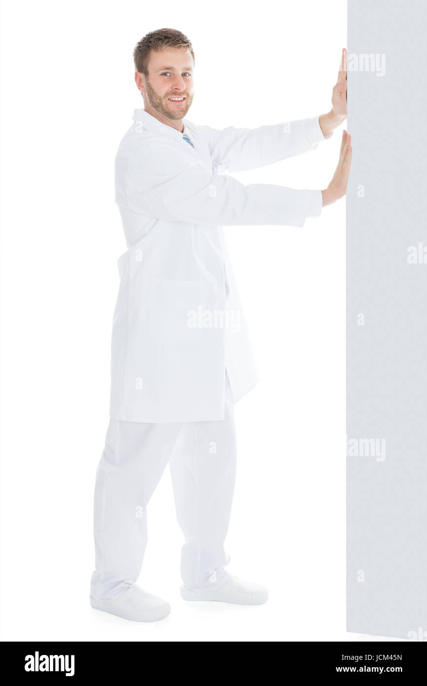 Full length side view of young male doctor pushing something over white ...
