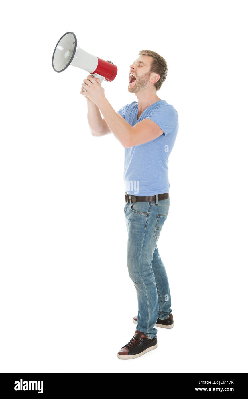 Full length of man screaming into megaphone over white background Stock ...