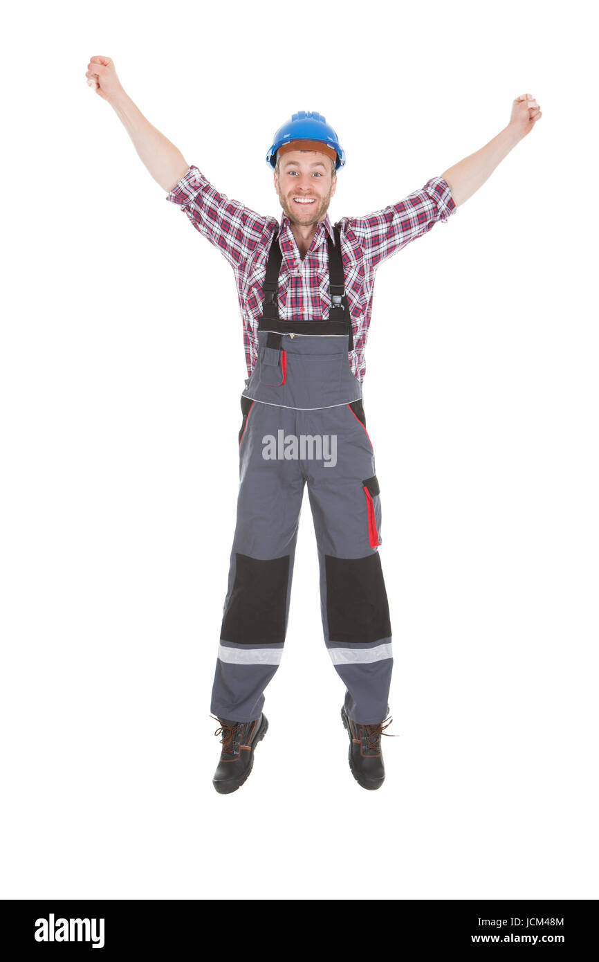 Full length of young manual worker screaming with hands raised over ...