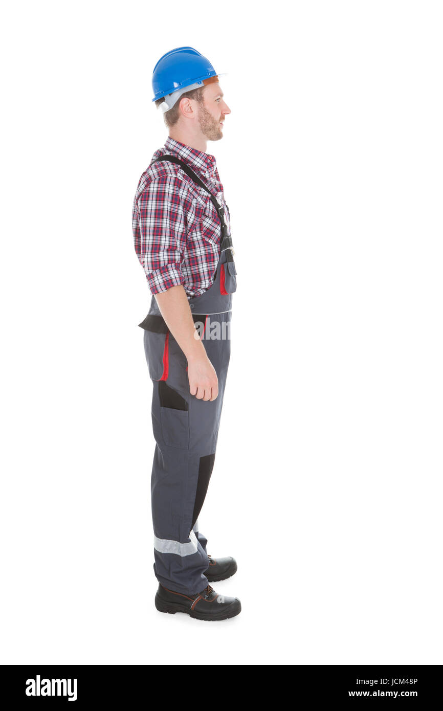 Full length side view of manual worker standing over white background ...