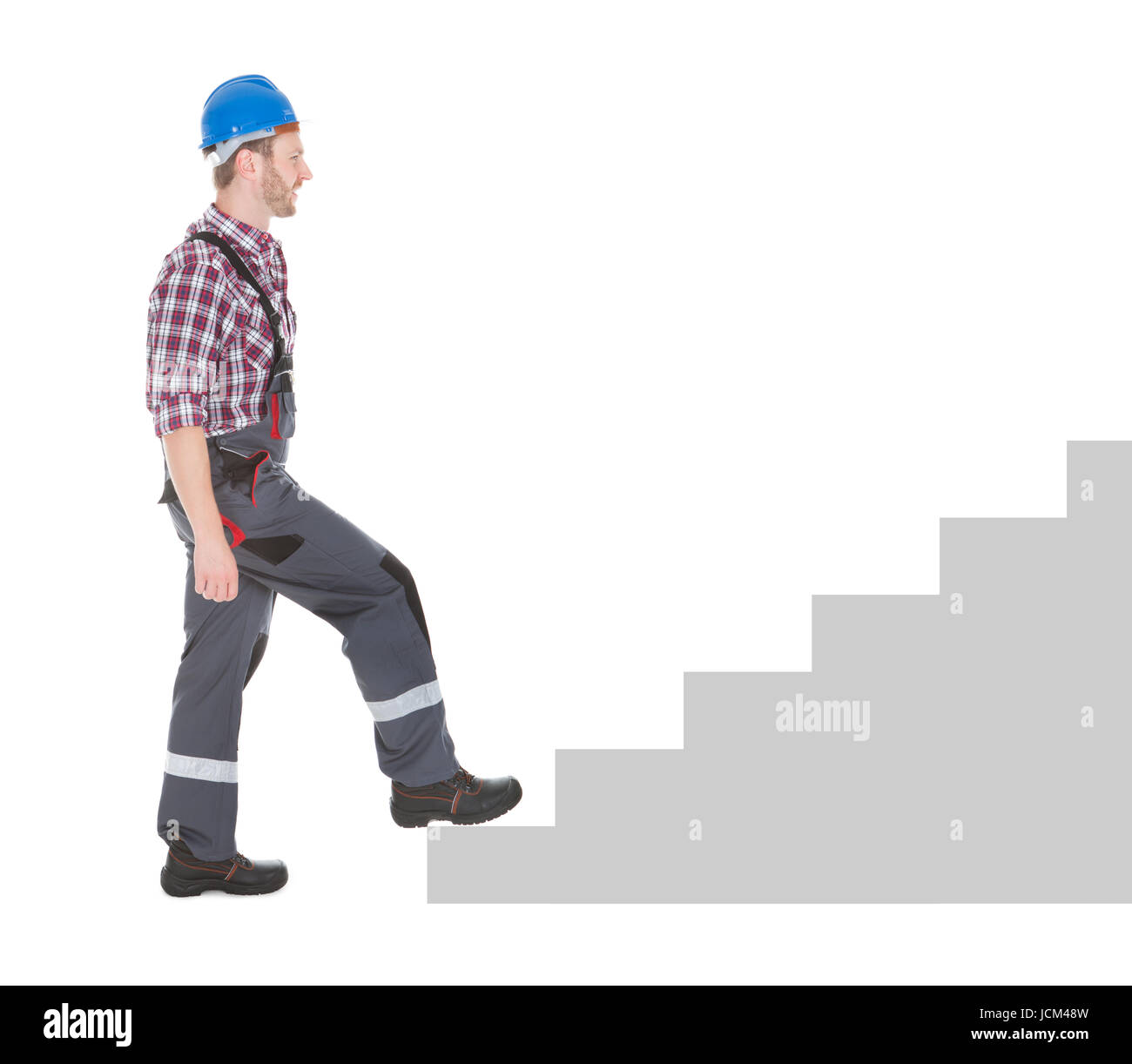 Full length side view of manual worker walking over white background ...