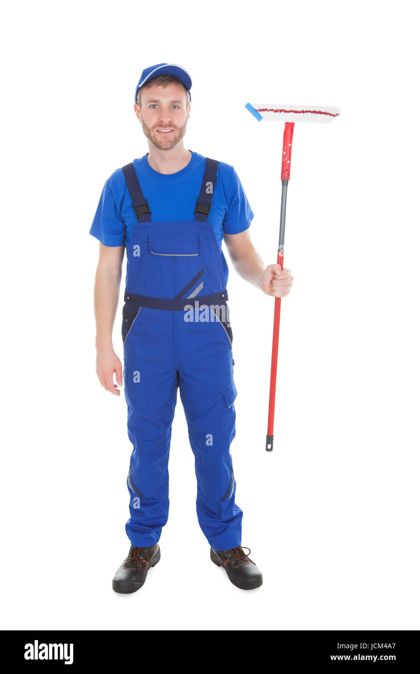 Full length portrait of confident young male cleaner holding mop ...