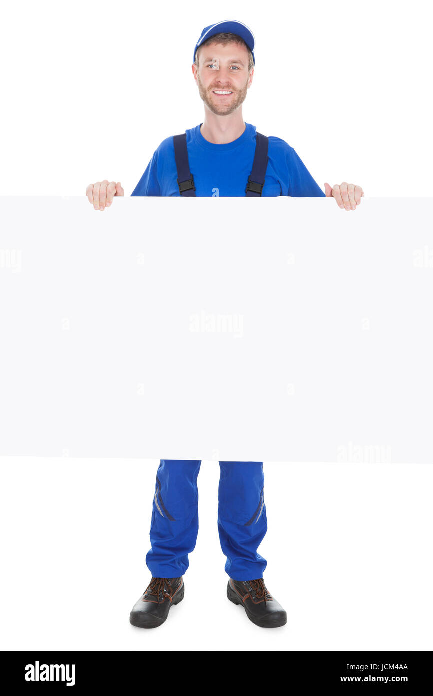 Full length portrait of smiling manual worker with billboard standing ...