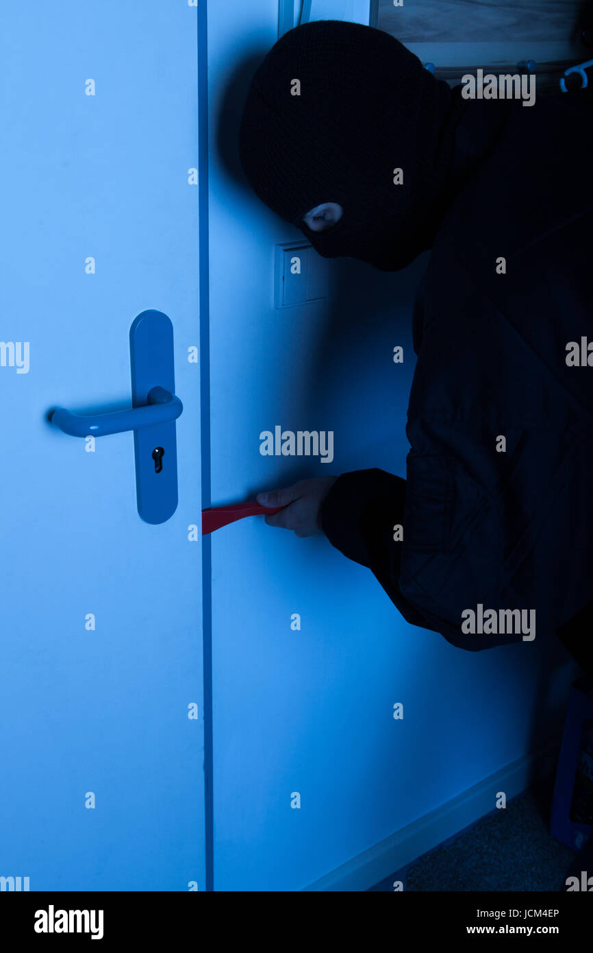 Thief opening door with crowbar during house breaking Stock Photo - Alamy