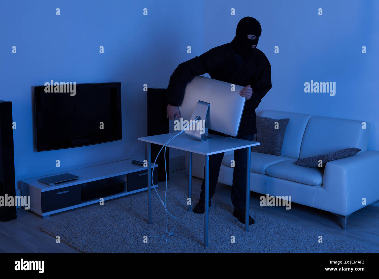Full length of thief stealing computer monitor from living room Stock ...