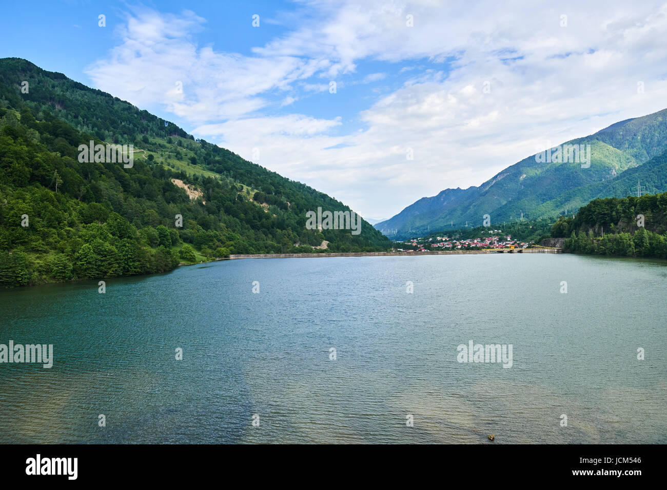 A dam lake and a town in the distance between mountains Stock Photo - Alamy