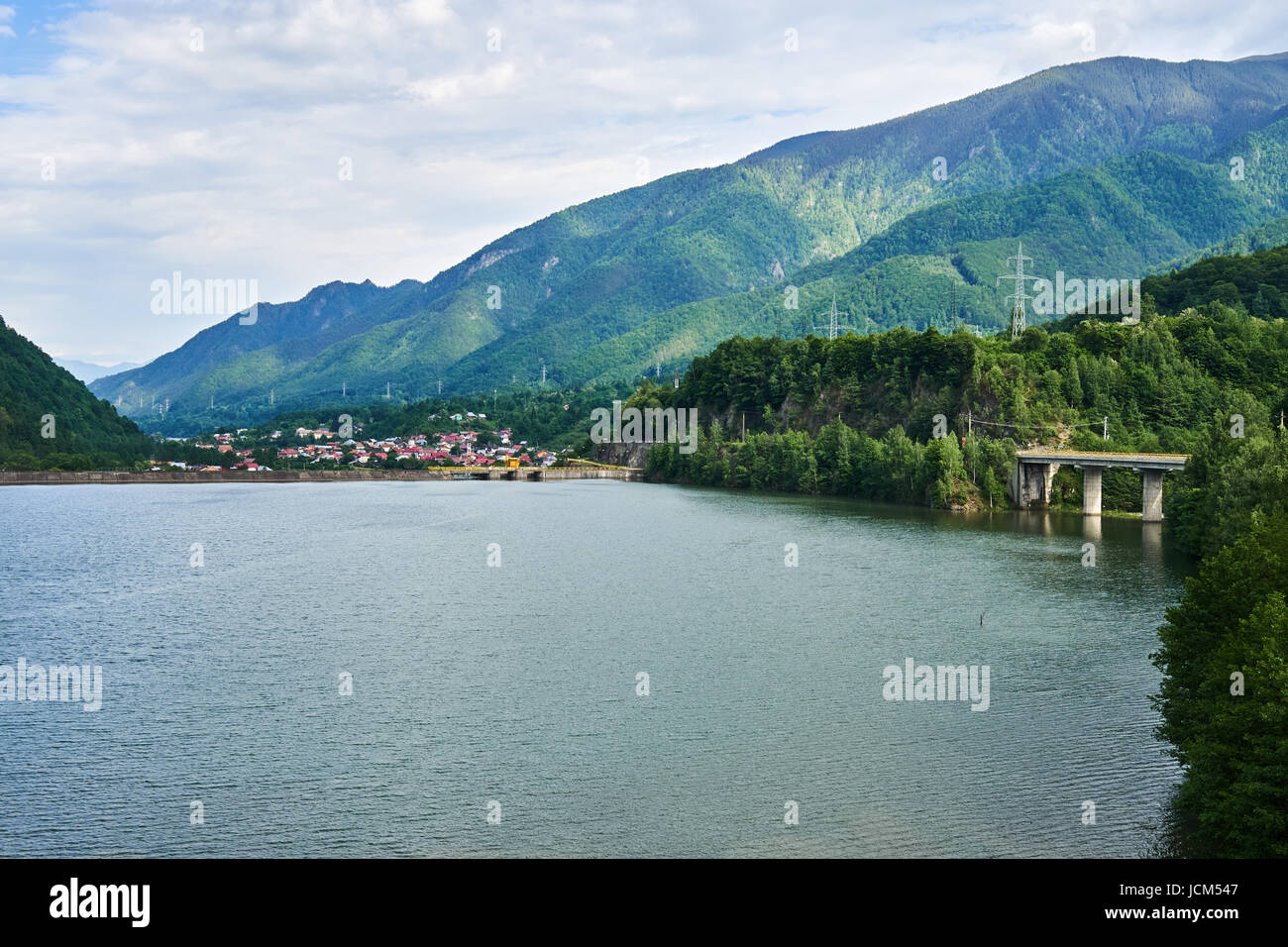 A dam lake and a town in the distance between mountains Stock Photo - Alamy