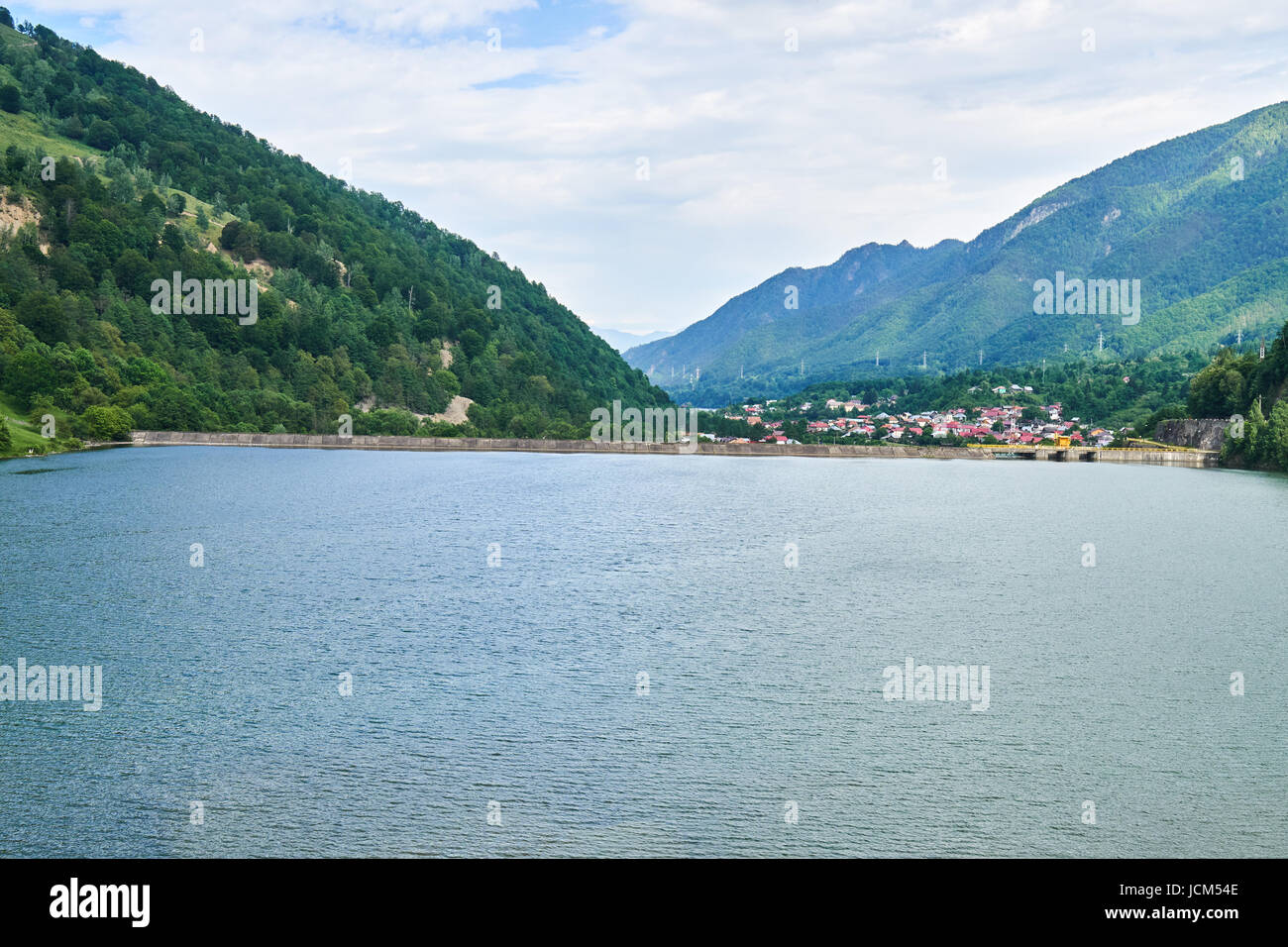 A dam lake and a town in the distance between mountains Stock Photo - Alamy